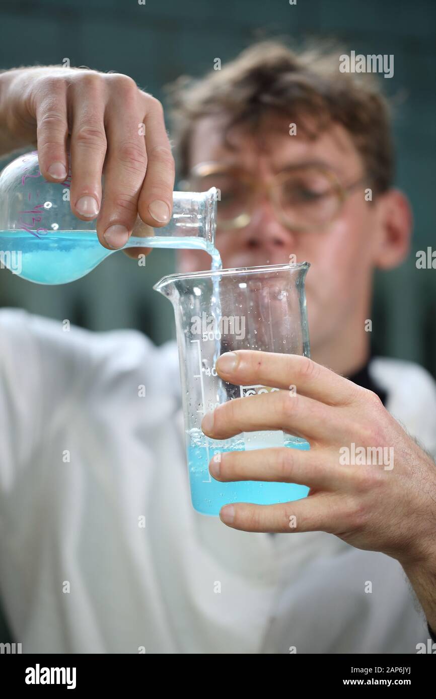A scientist in a laboratory pours a reagent into a measuring cup Stock ...