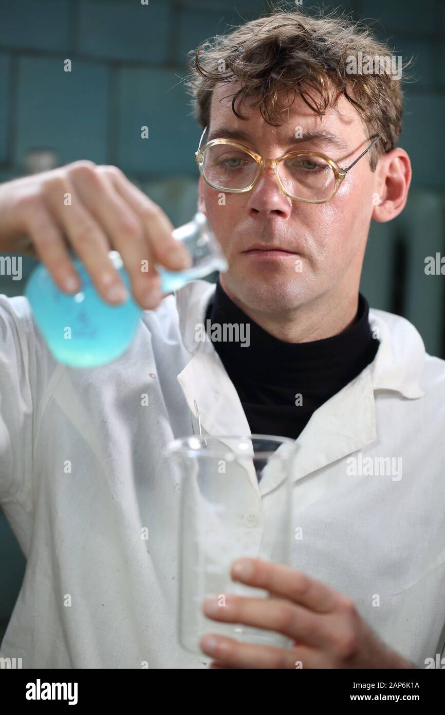 A scientist in a laboratory pours a reagent into a measuring cup Stock ...