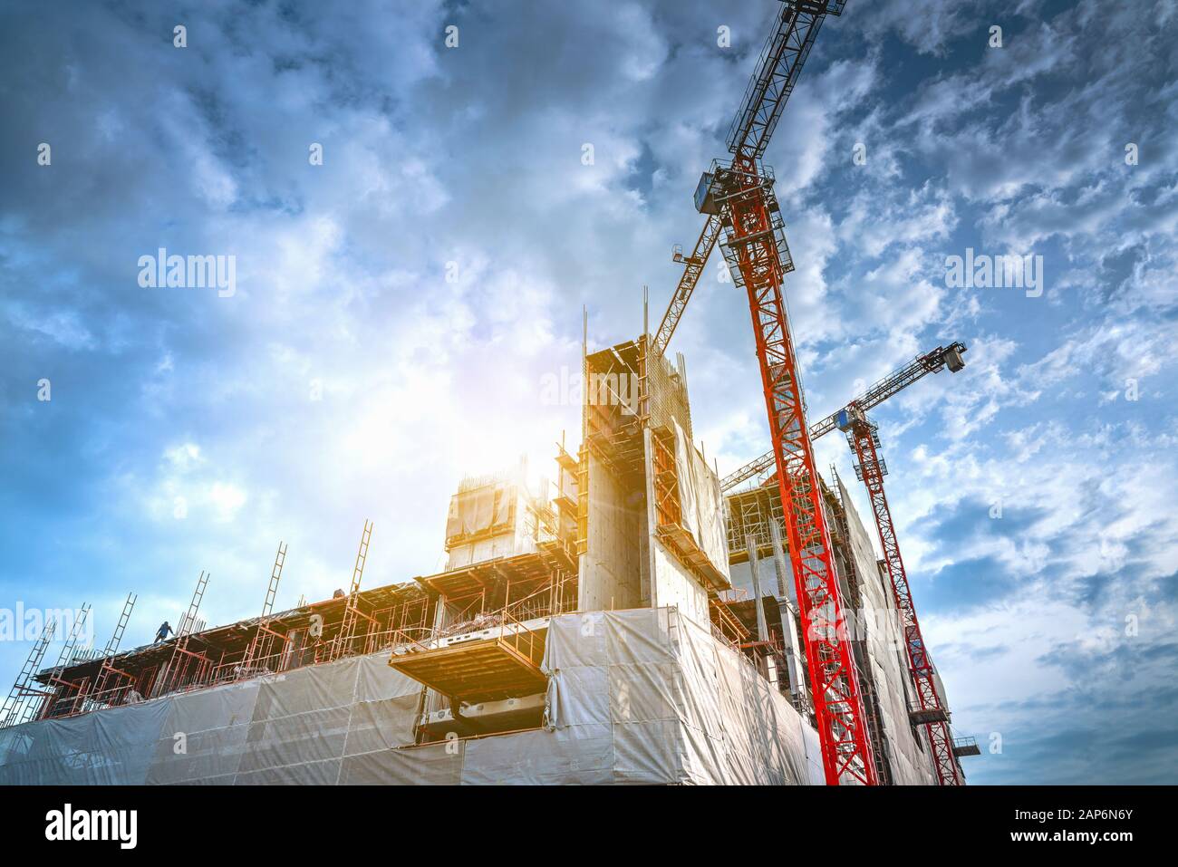 A team of workers is working and a large crane on the modern multi ...