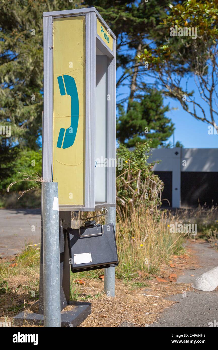 Old and abandoned Payphone booth with telephone book hanging loose ...