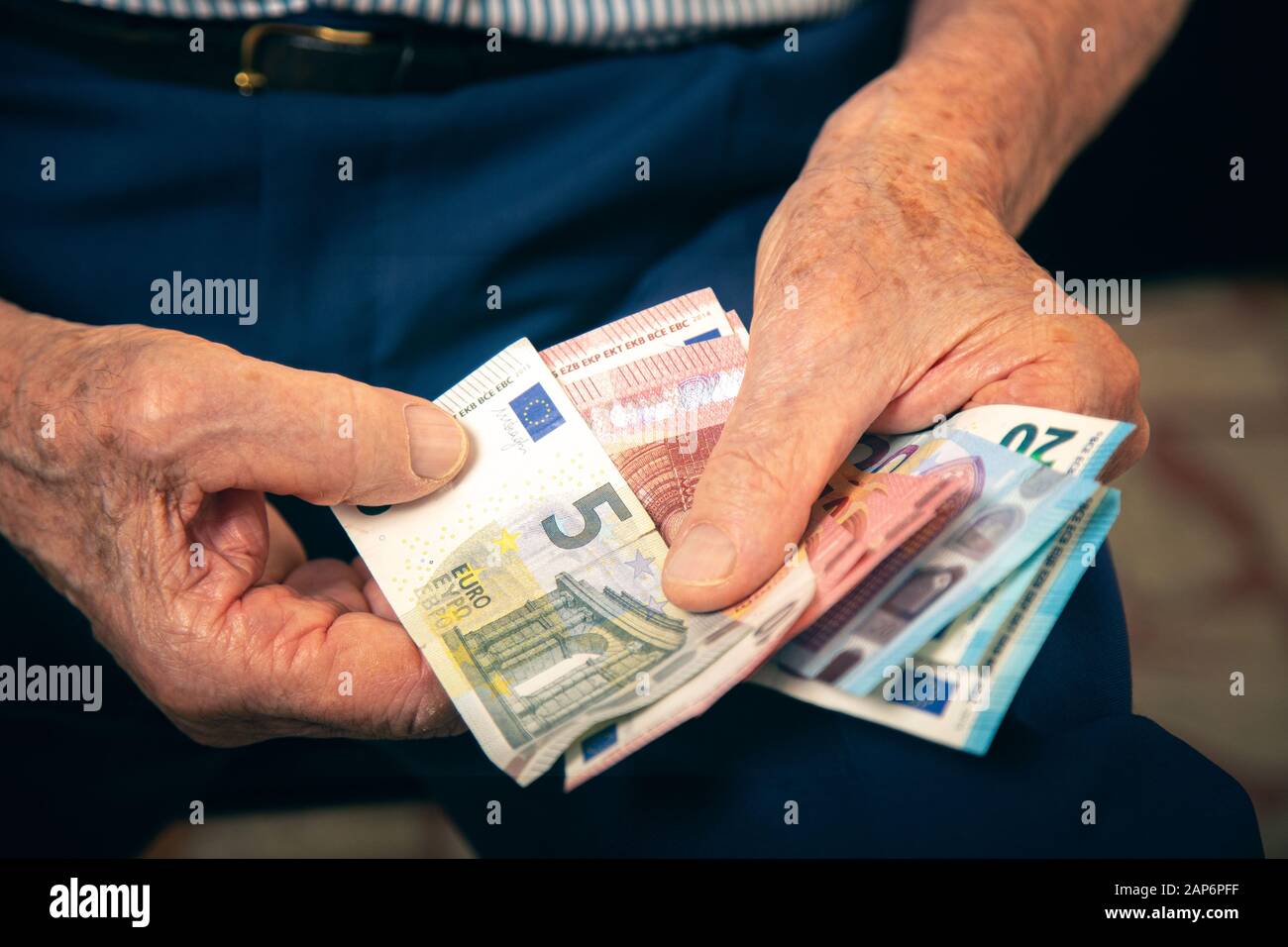 Old man sitting at home counting her money Stock Photo - Alamy
