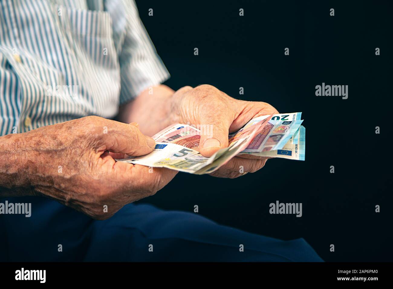 Old man sitting at home counting her money Stock Photo - Alamy