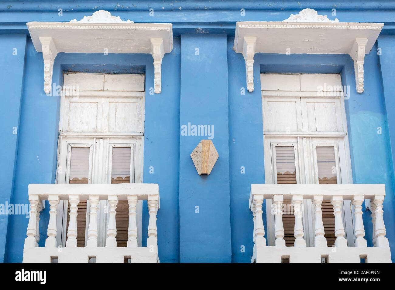 Two Spanish style white verandas on a blue wall Stock Photo - Alamy
