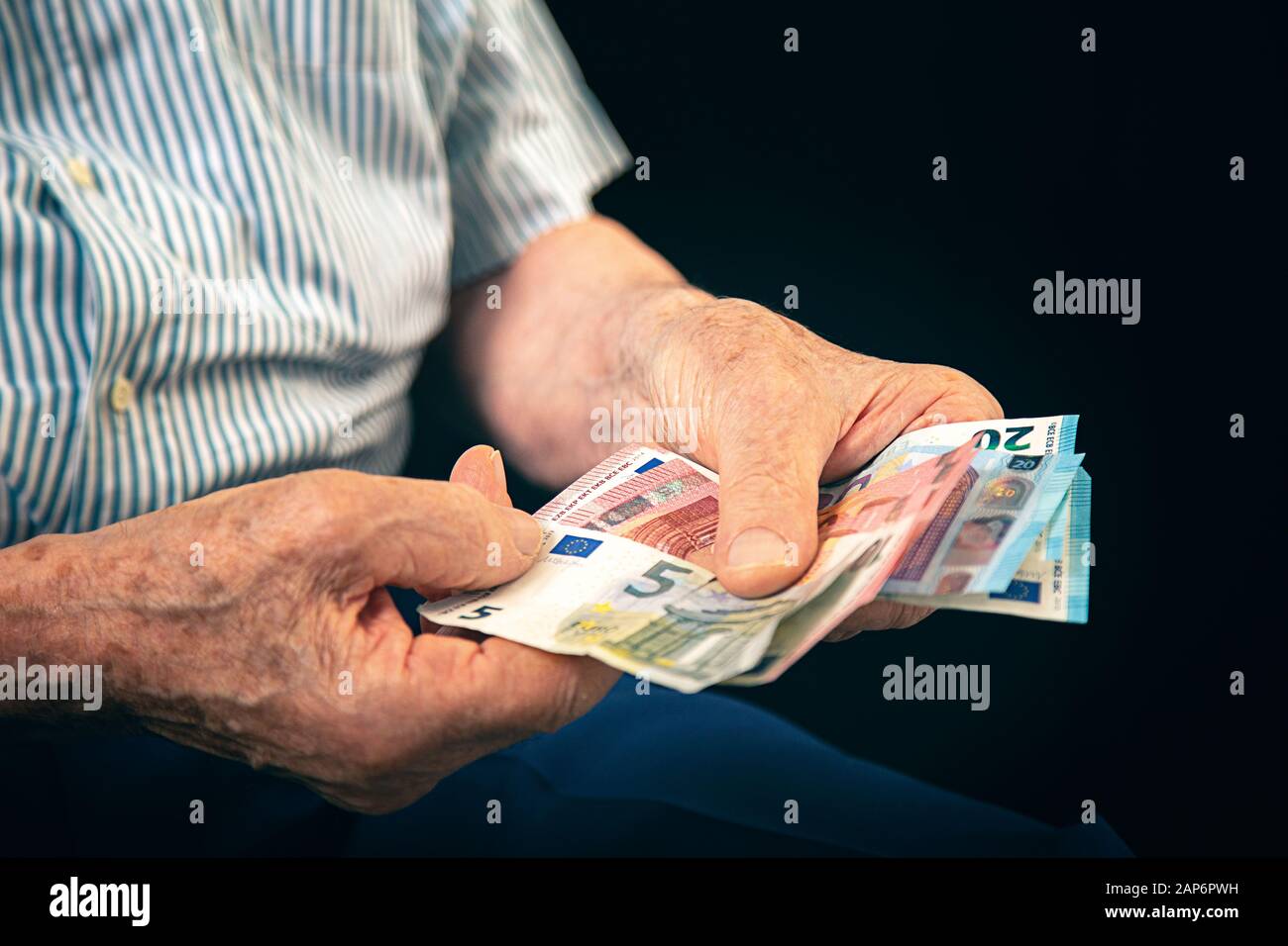 Old man sitting at home counting her money Stock Photo - Alamy