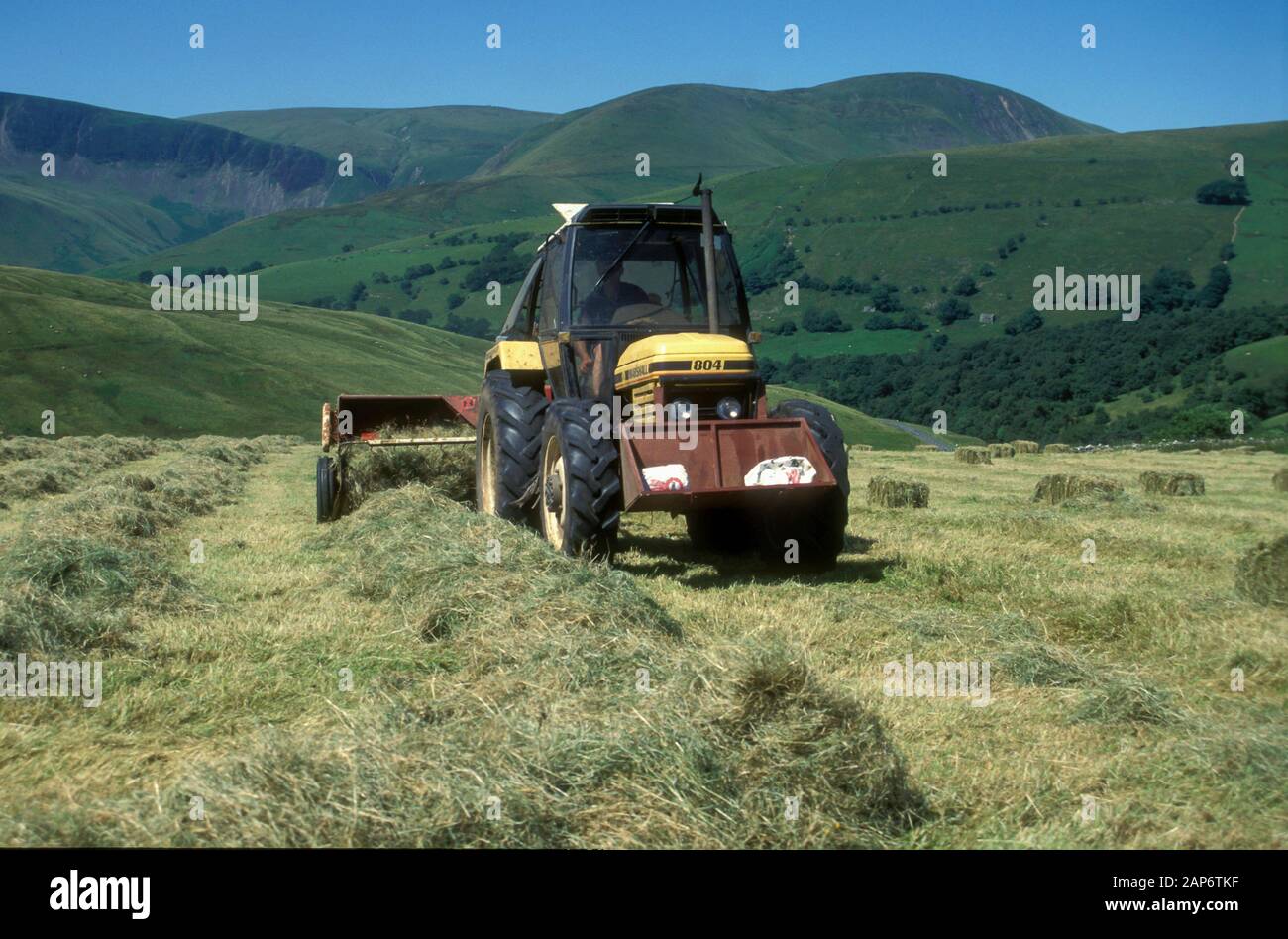 Farmer baling hay with a Marshall 804 tractor and an International ...