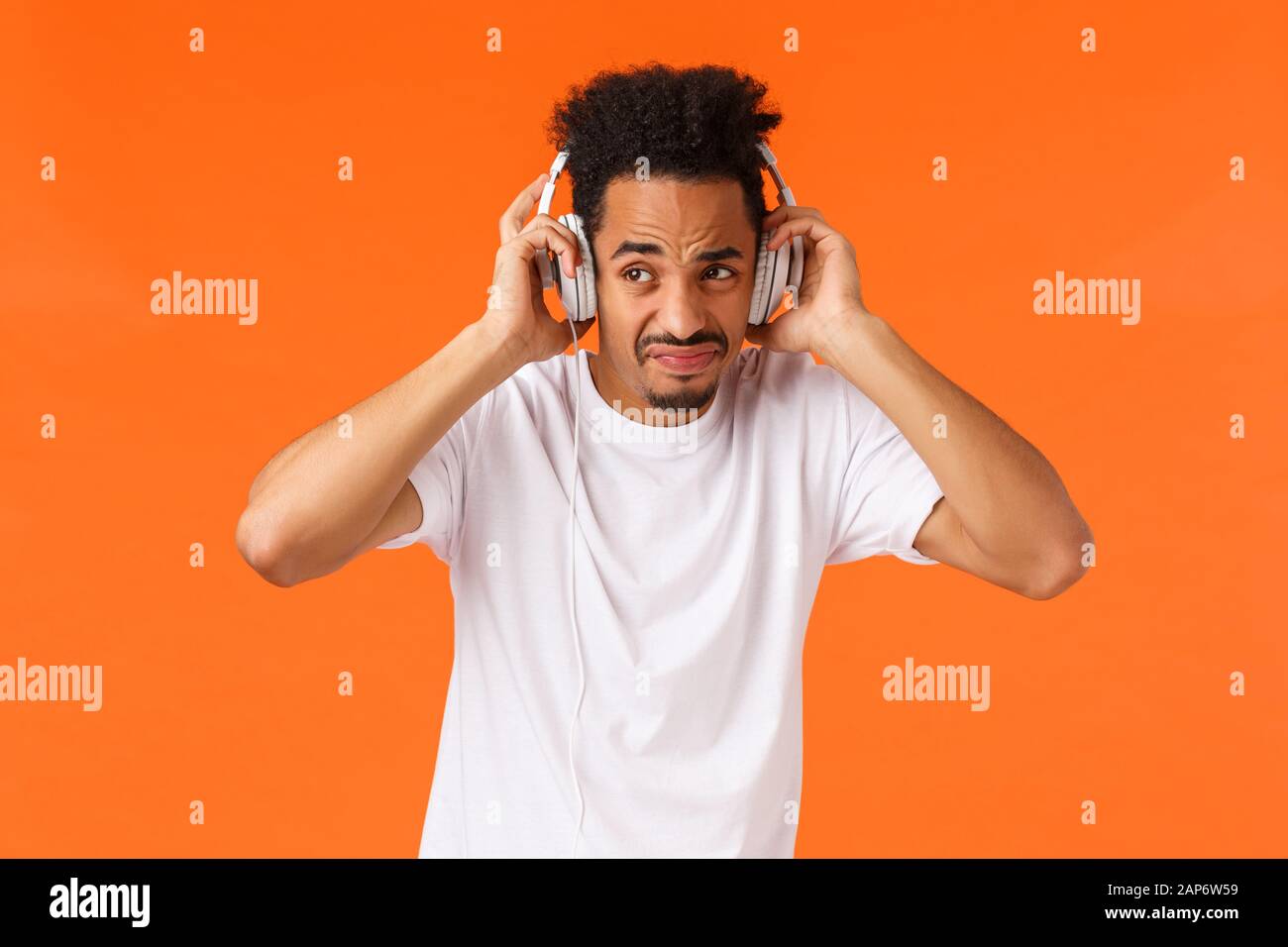 Guy cringing and grimacing from dislike and disapproval, unwilling hear ...