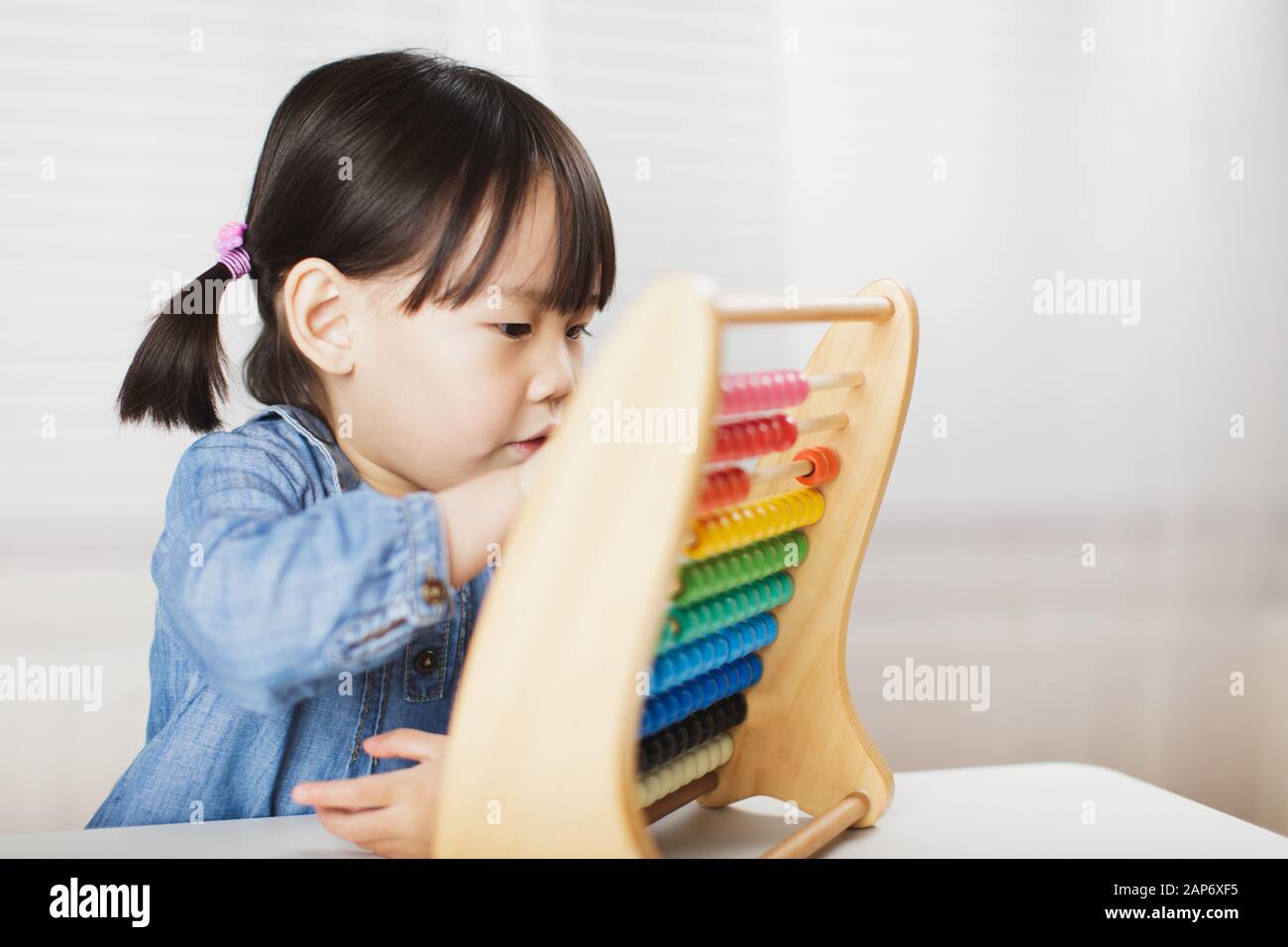 toddler girl play abacus for learning math at home against white ...
