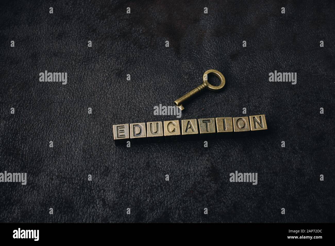 Retro styled decorative key and education wording on dark background ...
