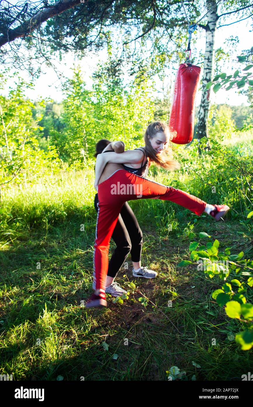 two diverse nations girls fighting boxing outside in green park, sport ...