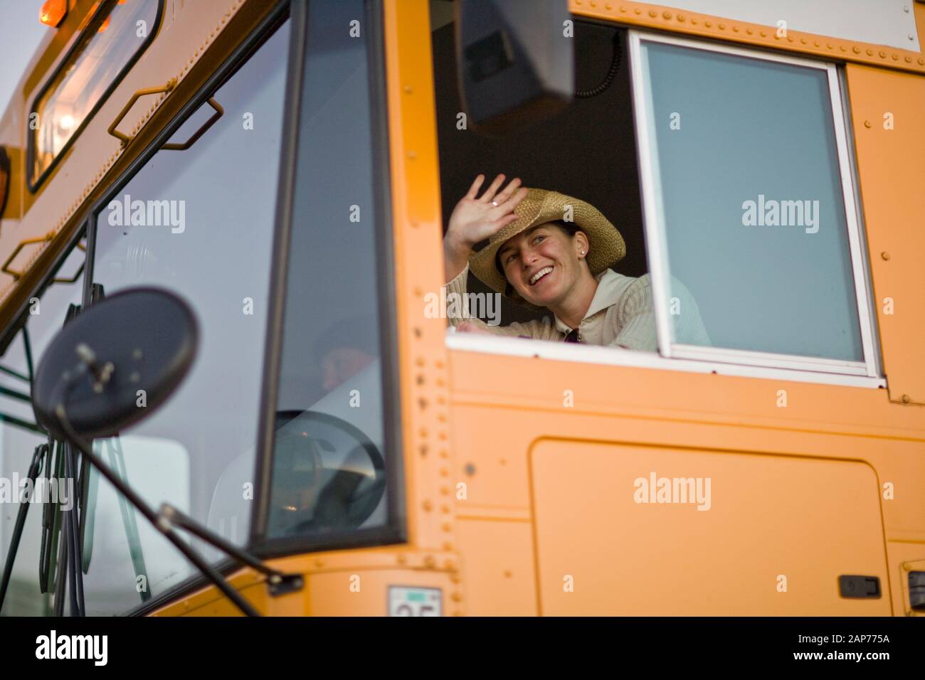 Woman driving a yellow school bus and waving Stock Photo - Alamy