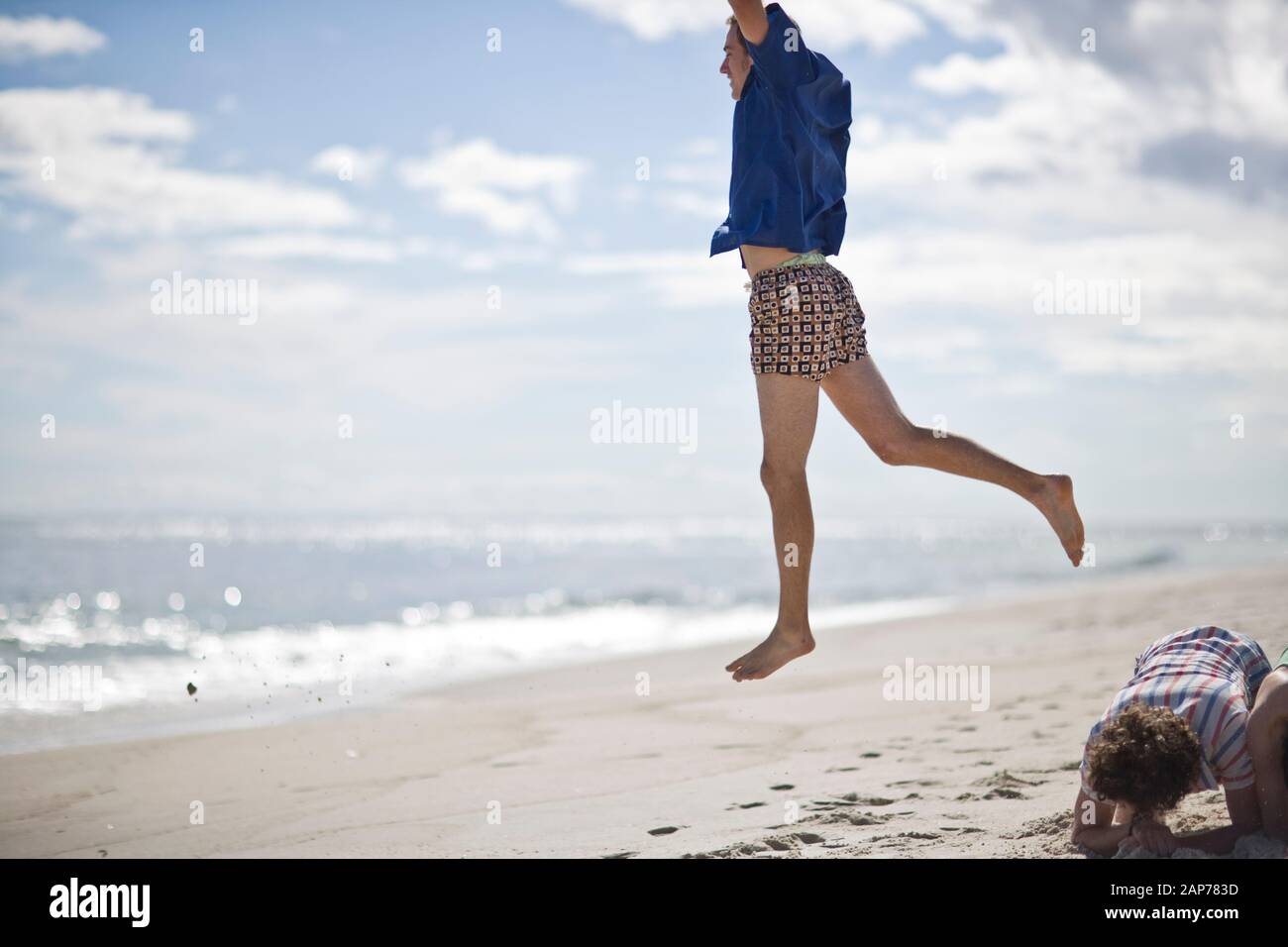 Friends playing leapfrog on the beach Stock Photo - Alamy
