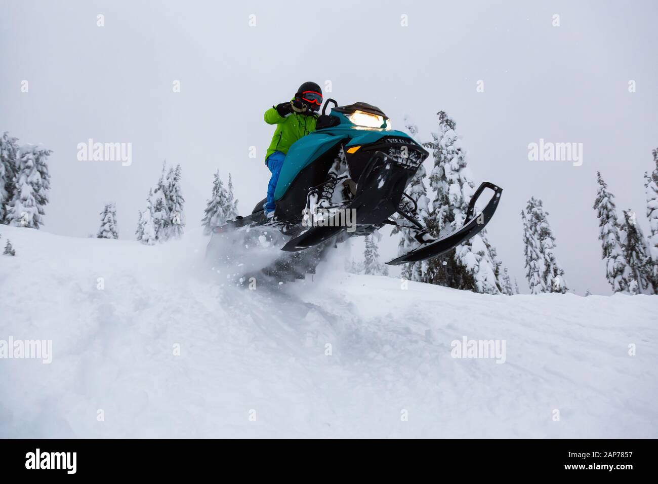 Adventurous Man Riding a Snowmobile in white snow Stock Photo - Alamy