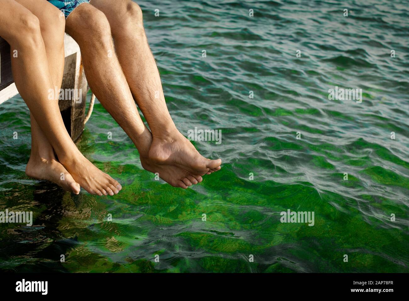 Two people sitting side by side on a pier Stock Photo - Alamy Two people sitting side by side on a pier Stock Photo - Alamy