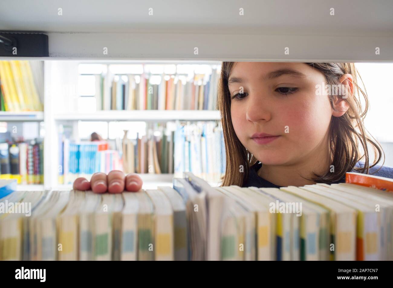 Young girl selecting books from library bookshelf. Children creativity ... Young girl selecting books from library bookshelf. Children creativity ...