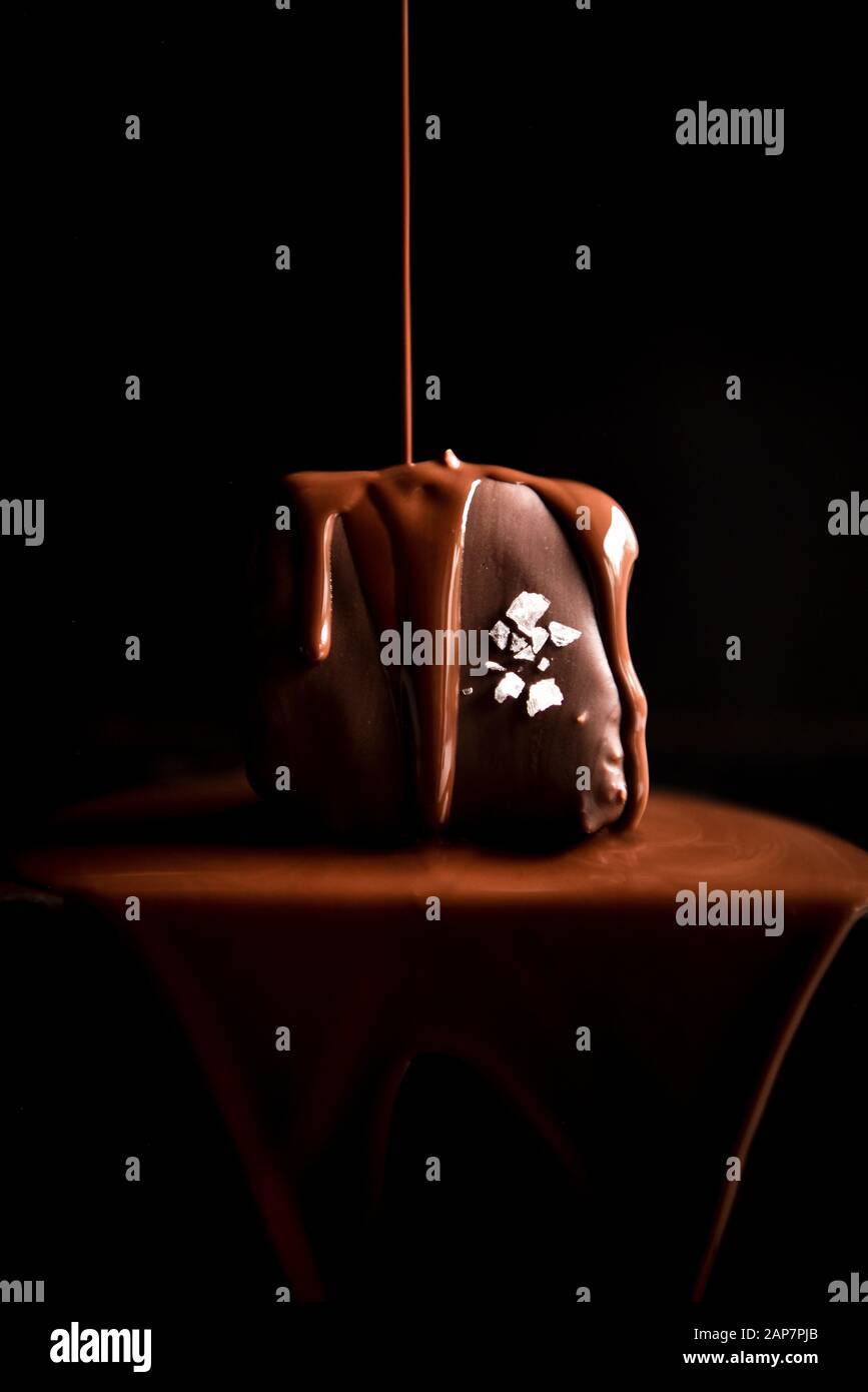 Chocolate bite cake being covered in chocolate sauce Stock Photo - Alamy