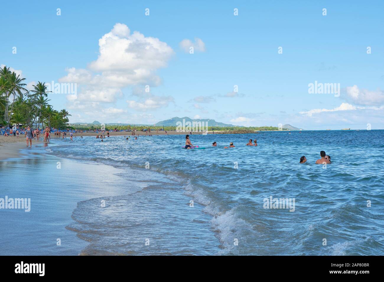 Vacationers enjoy the beach and surf of Playa Dorado near Puerto Plata ...