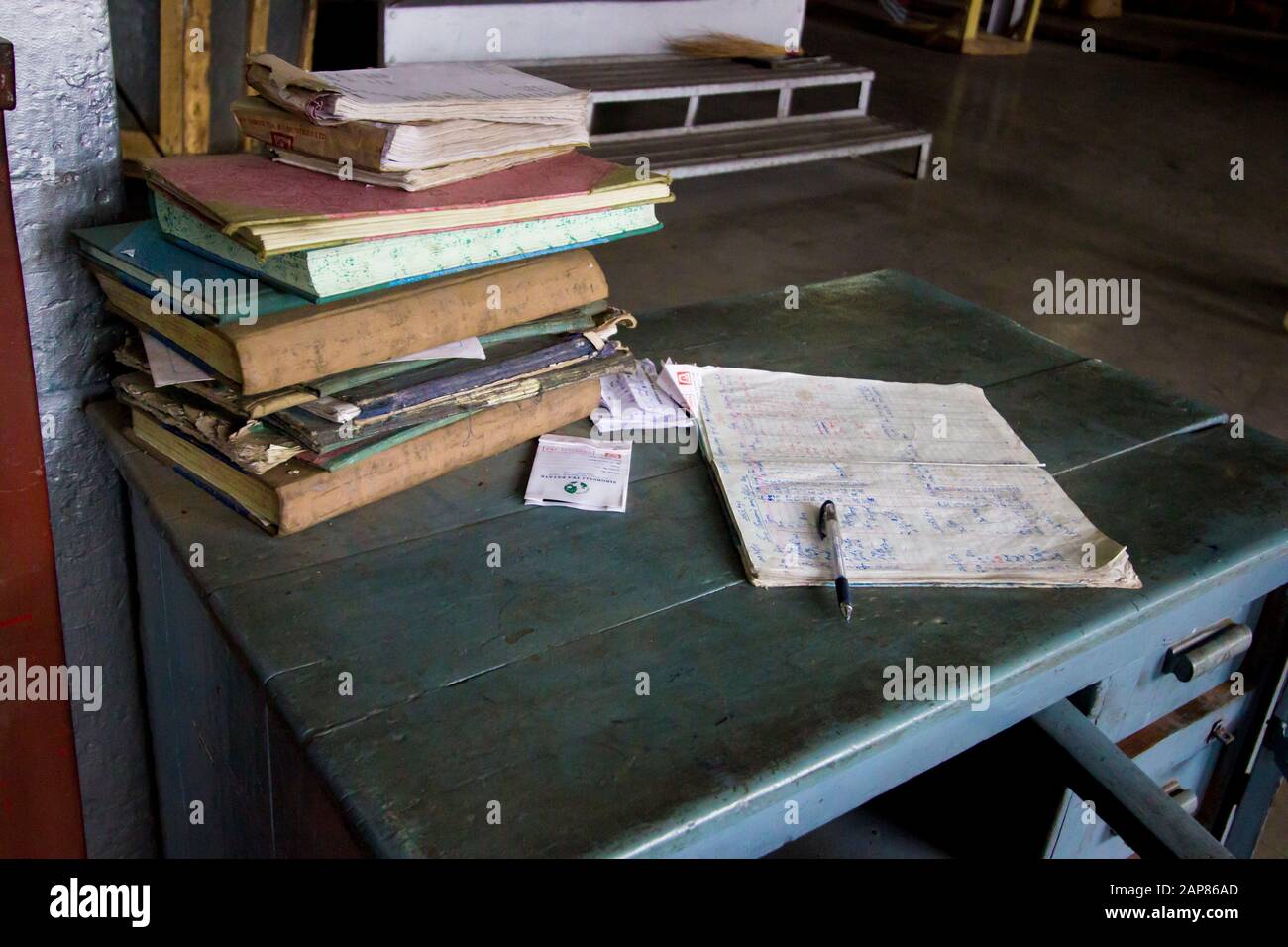 An old desk, stacked with ledgers and handwritten log notes at the ...