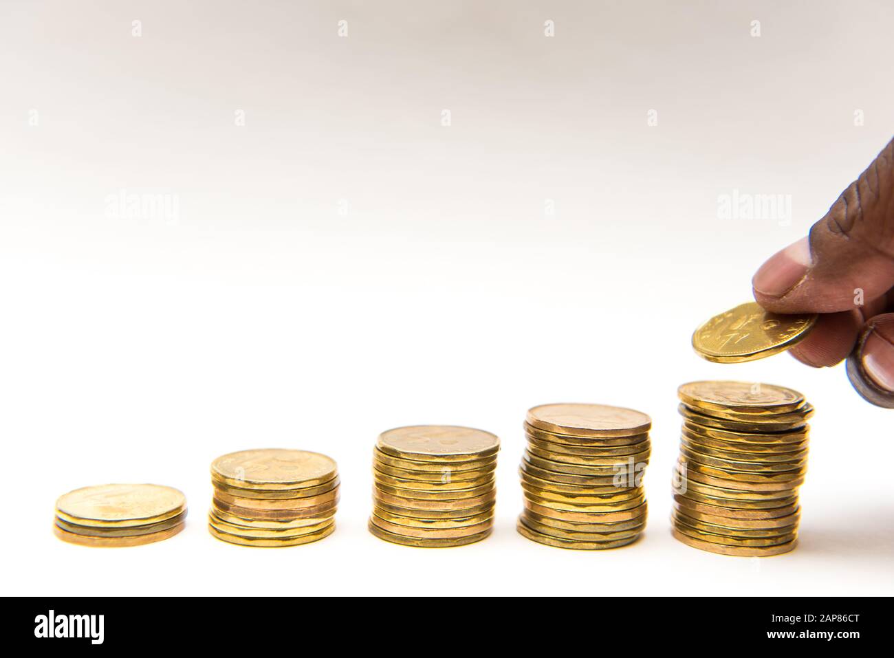 Canadian Dollar coins tacked into five ascending piles on white ...