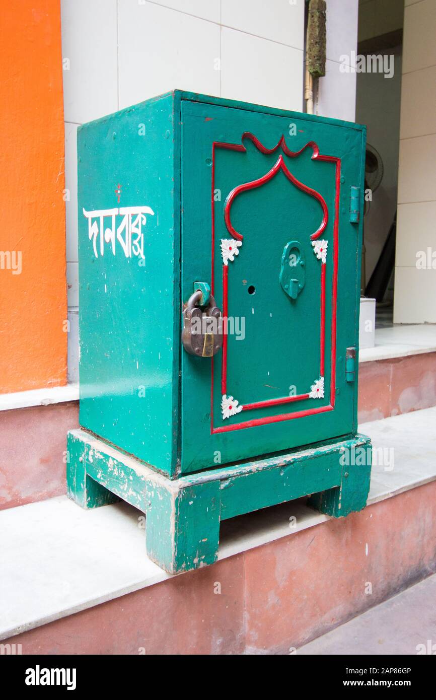 A painted green donation safe, box, outside a temple. In Kolkata ...