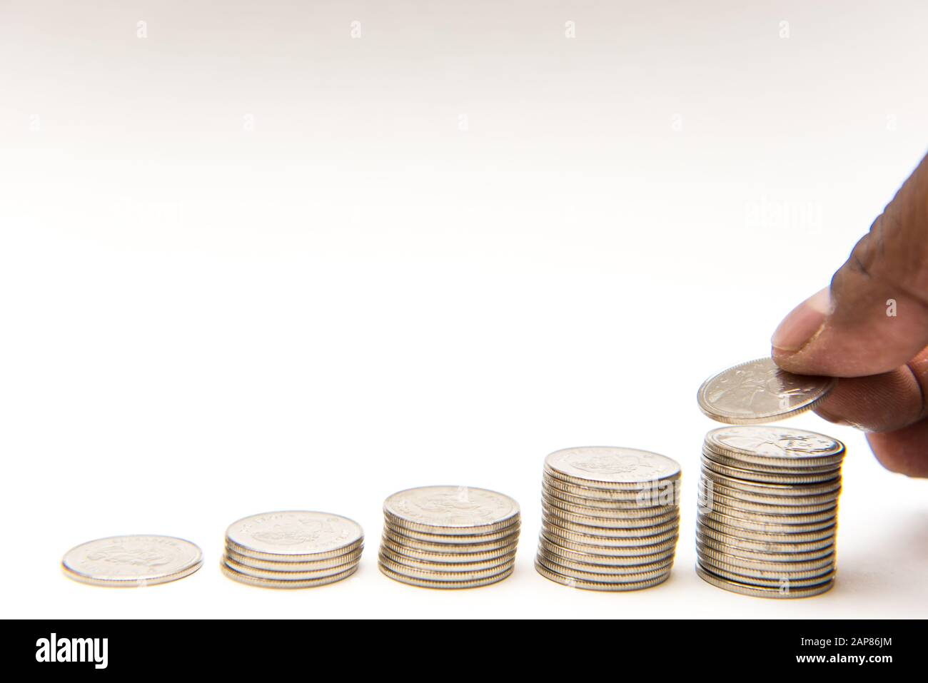 Canadian Quarters stacked into five ascending piles on white background ...