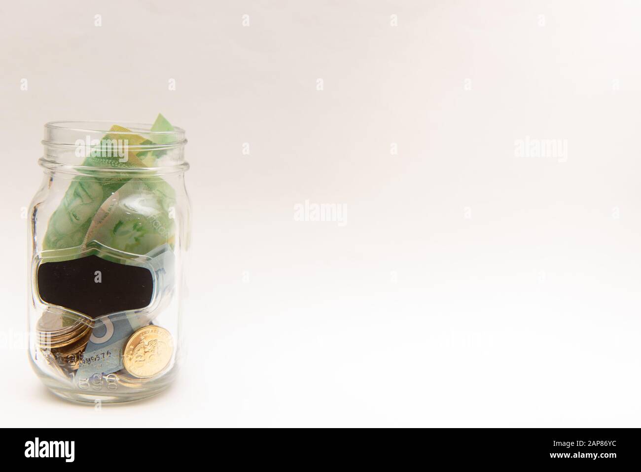 Transparent glass jar with money inside on top of wooden table. Concept ...