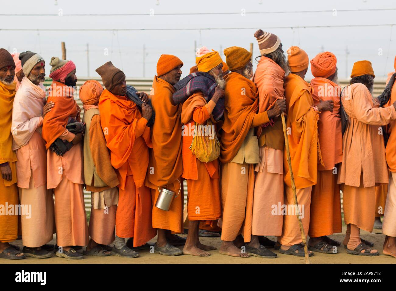 Ascetic, orange robe Sahdus line up for a meal. At the Kumbh Mela Hindu ...