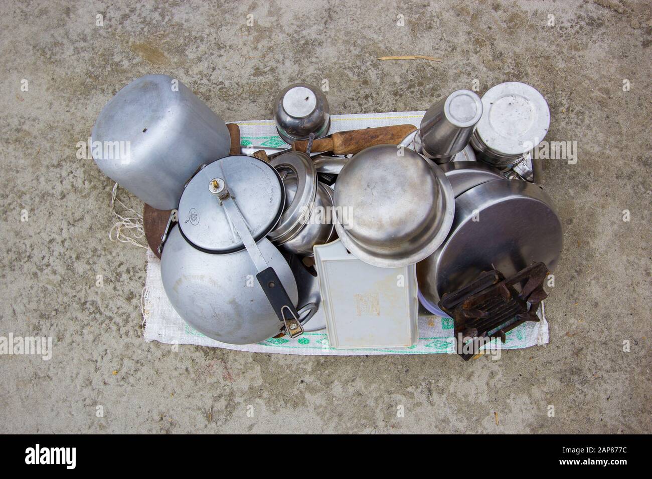 Just washed, clean dishes and pans neatly stacked on a towel. At the ...