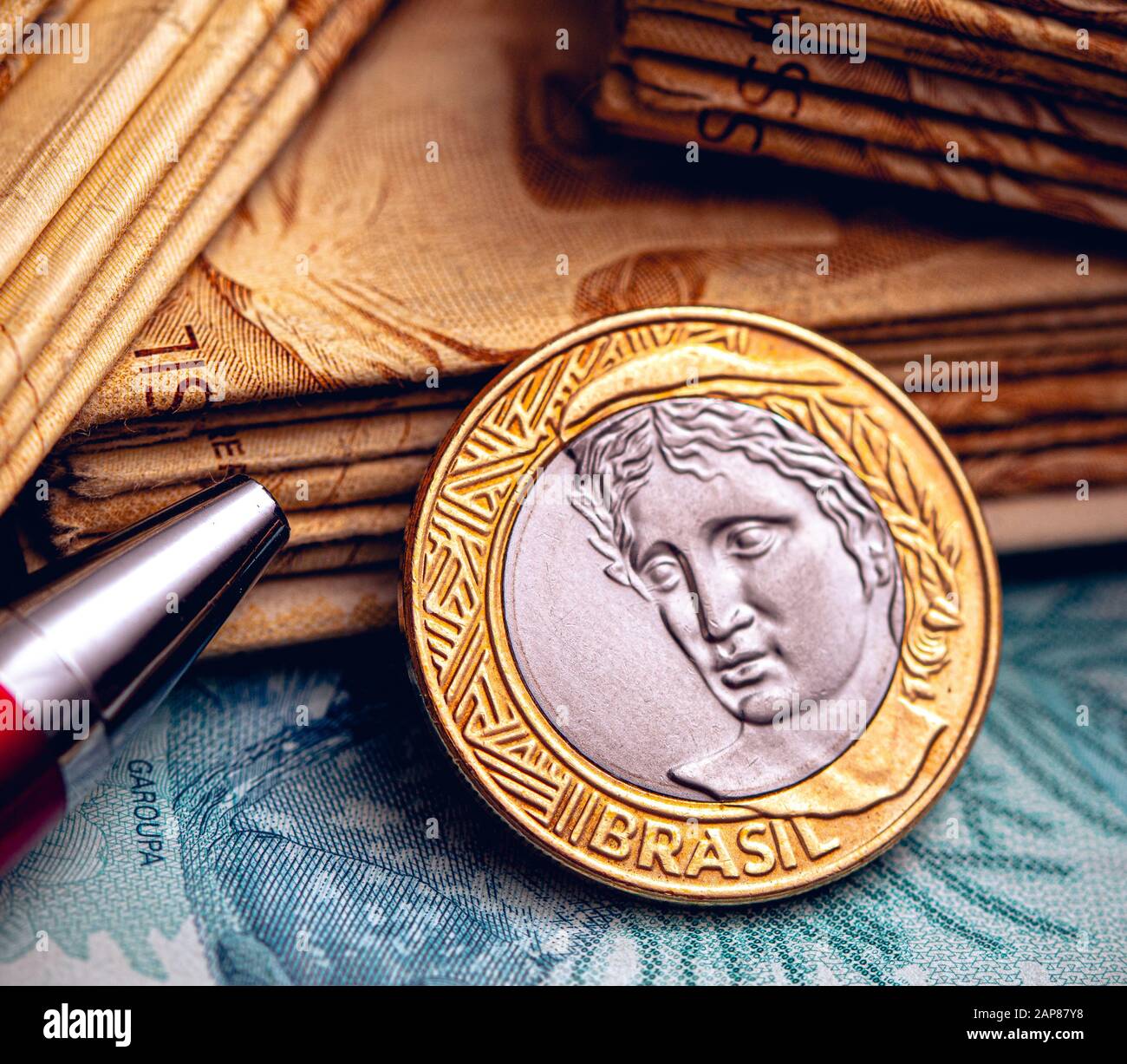 Brazilian Real - BRL. Photograph of a one Real coin over many money ...