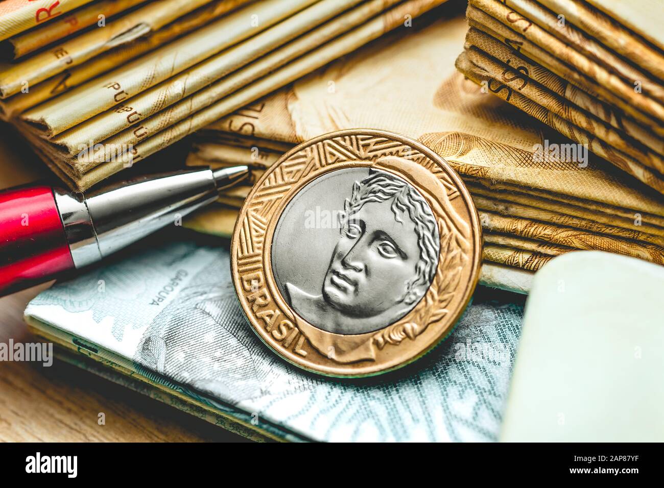 Brazilian Real - BRL. Photograph of a one Real coin over many money ...