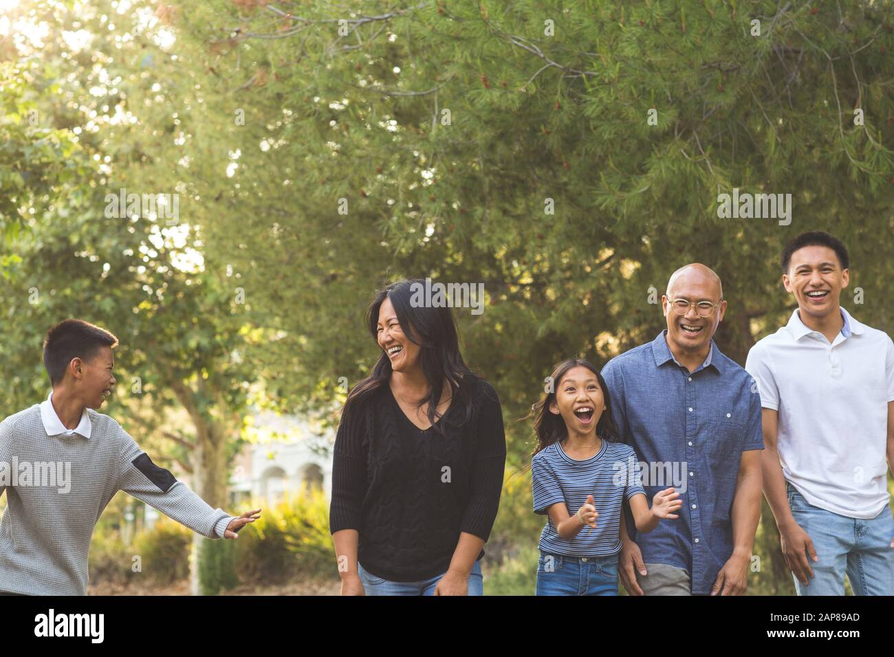 Happy Asian family walking and talking outside Stock Photo - Alamy
