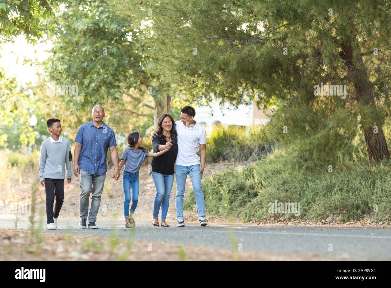 Happy Asian family walking and talking outside Stock Photo - Alamy