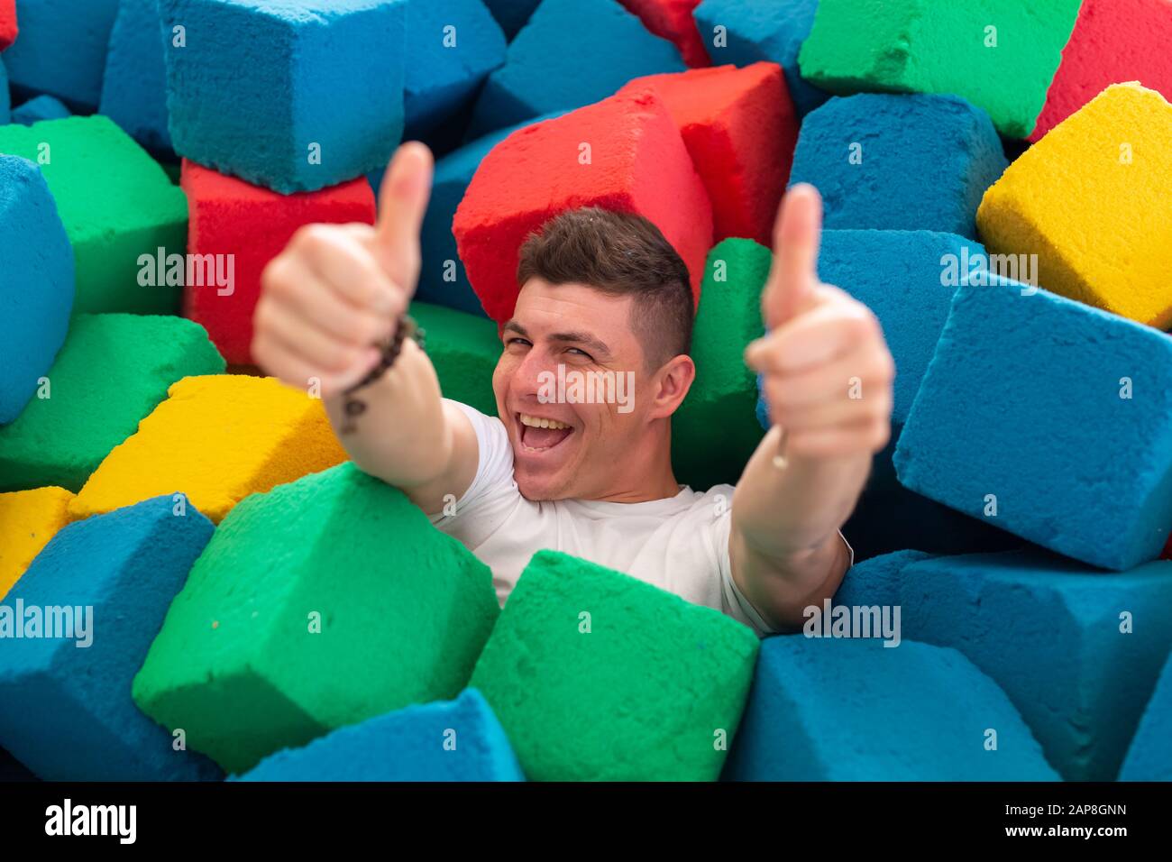 Funny happy man having fun on a trampoline indoors Stock Photo - Alamy