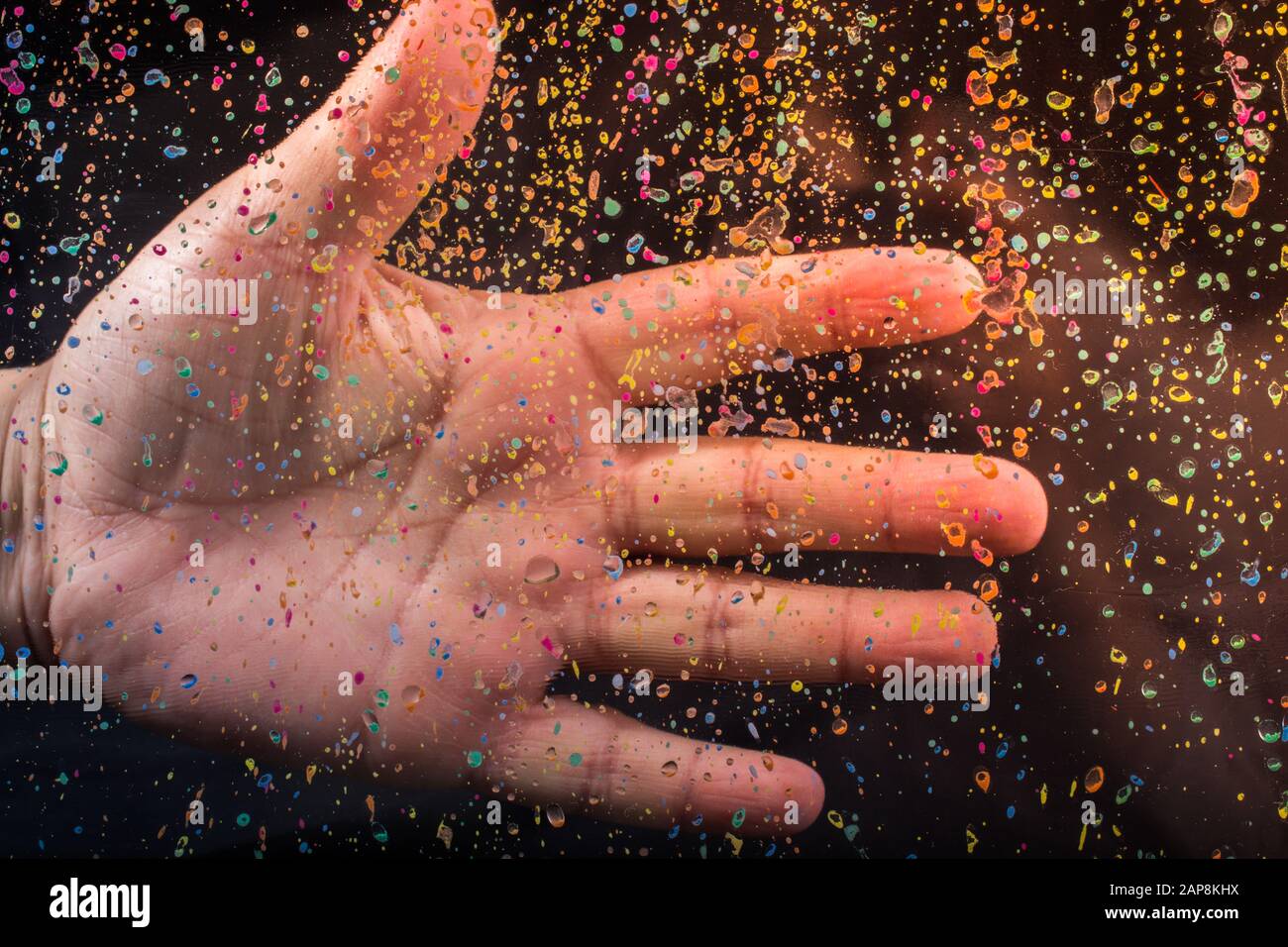 Hand on a glass with a paint splash effect on a black background Stock ...