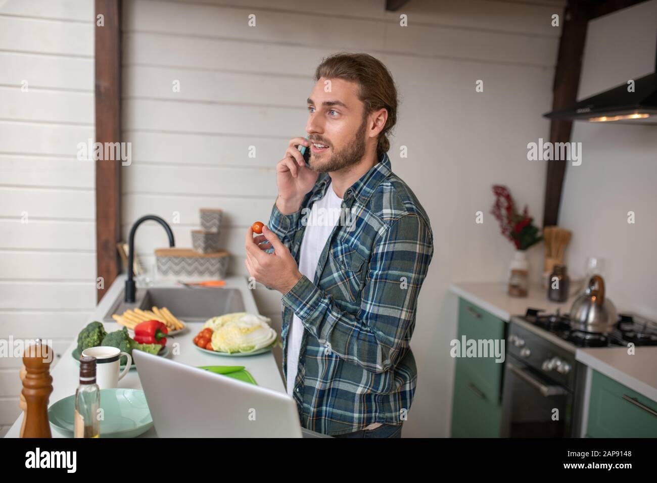 Man making a phone call while cooking Stock Photo - Alamy