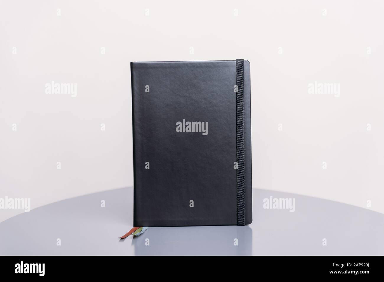 Black book, agenda or planner standing on a grey surface and white ...