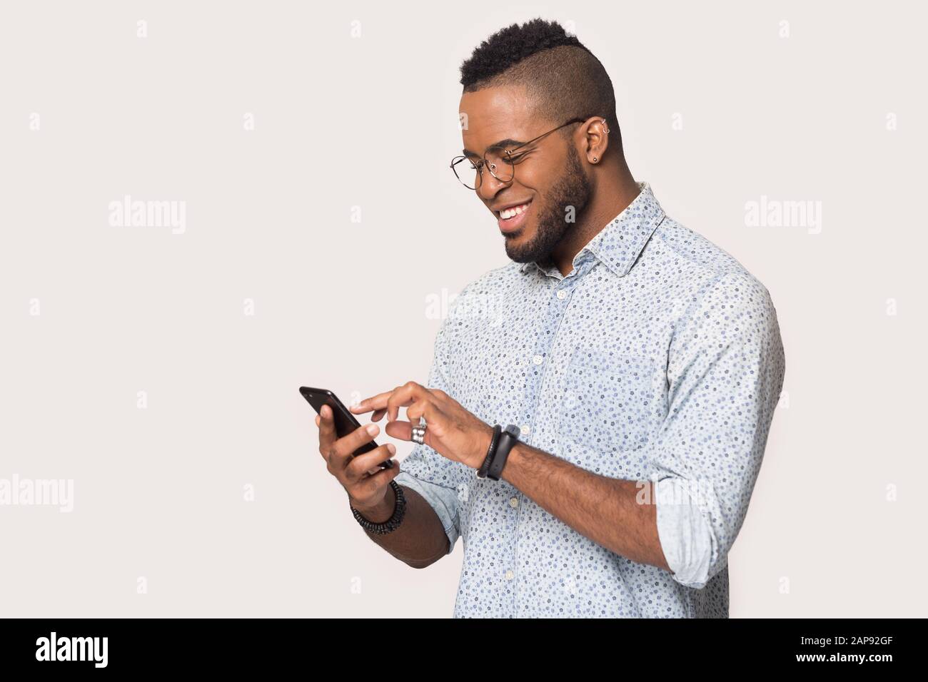 Happy black man using smartphone get pleasant message Stock Photo - Alamy