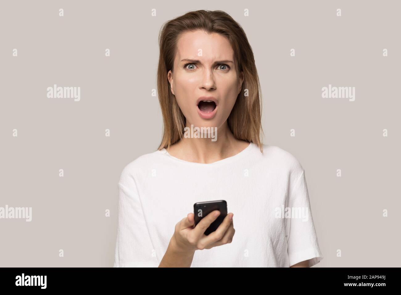Mad young woman hold cellphone frustrated by phone malfunction Stock ...