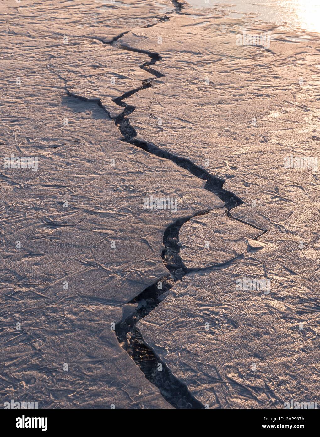Cracked surface layer of ice at frozen lake Stock Photo - Alamy