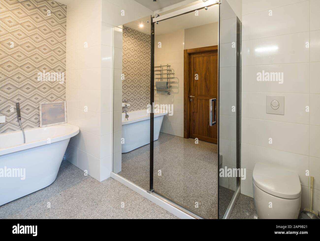 Bath with shower in bathroom. Mirror on the wall. Reflection of cosed ...