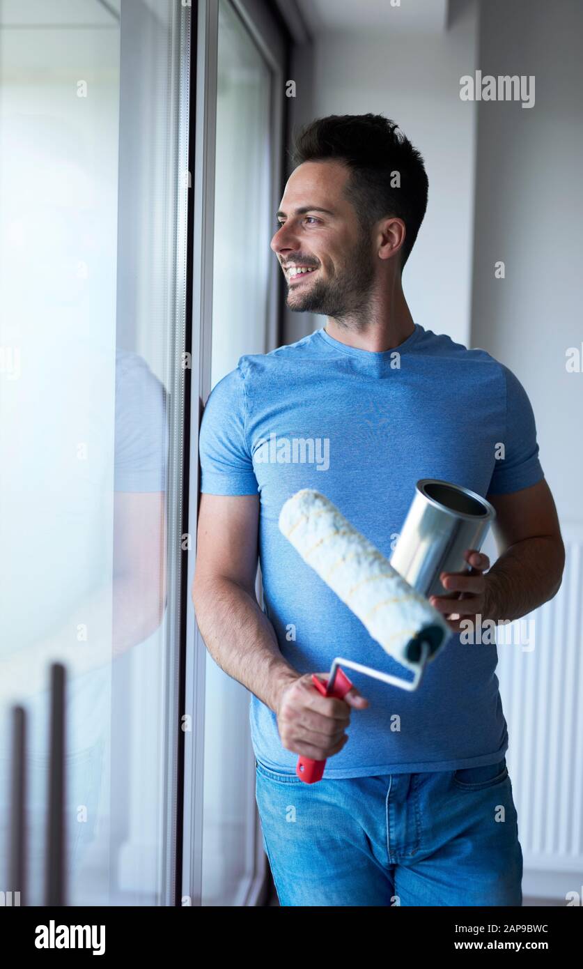 Man catching a short break while doing some housework Stock Photo - Alamy