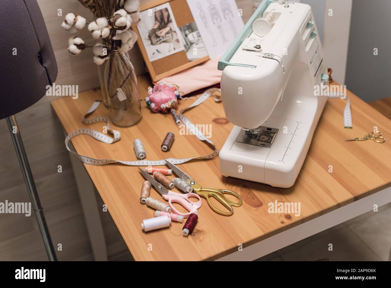 The workplace of a seamstress. Sewing machine on the table, thread ...