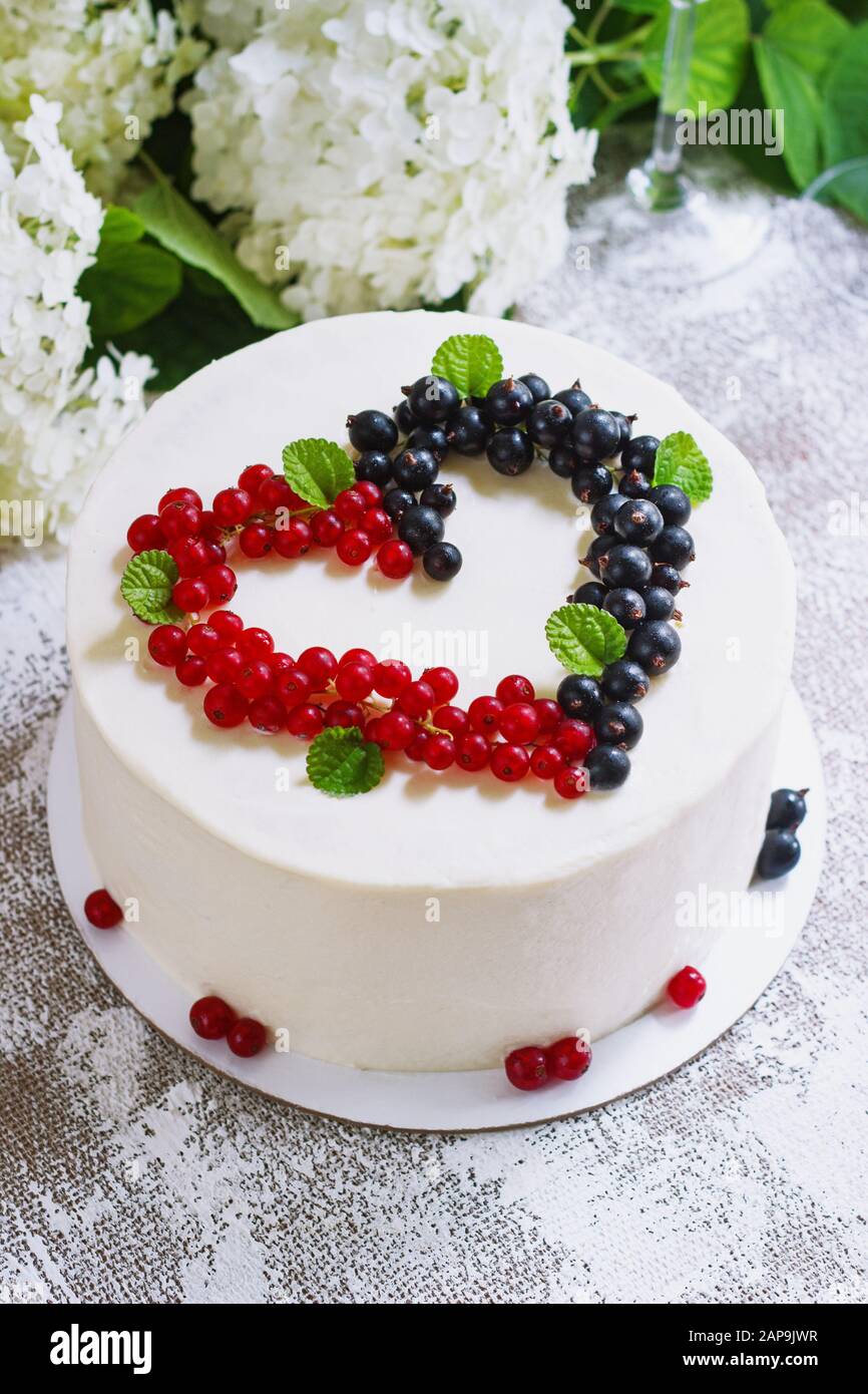Round white cake with berries in the form of hearts, Valentine's Day ...