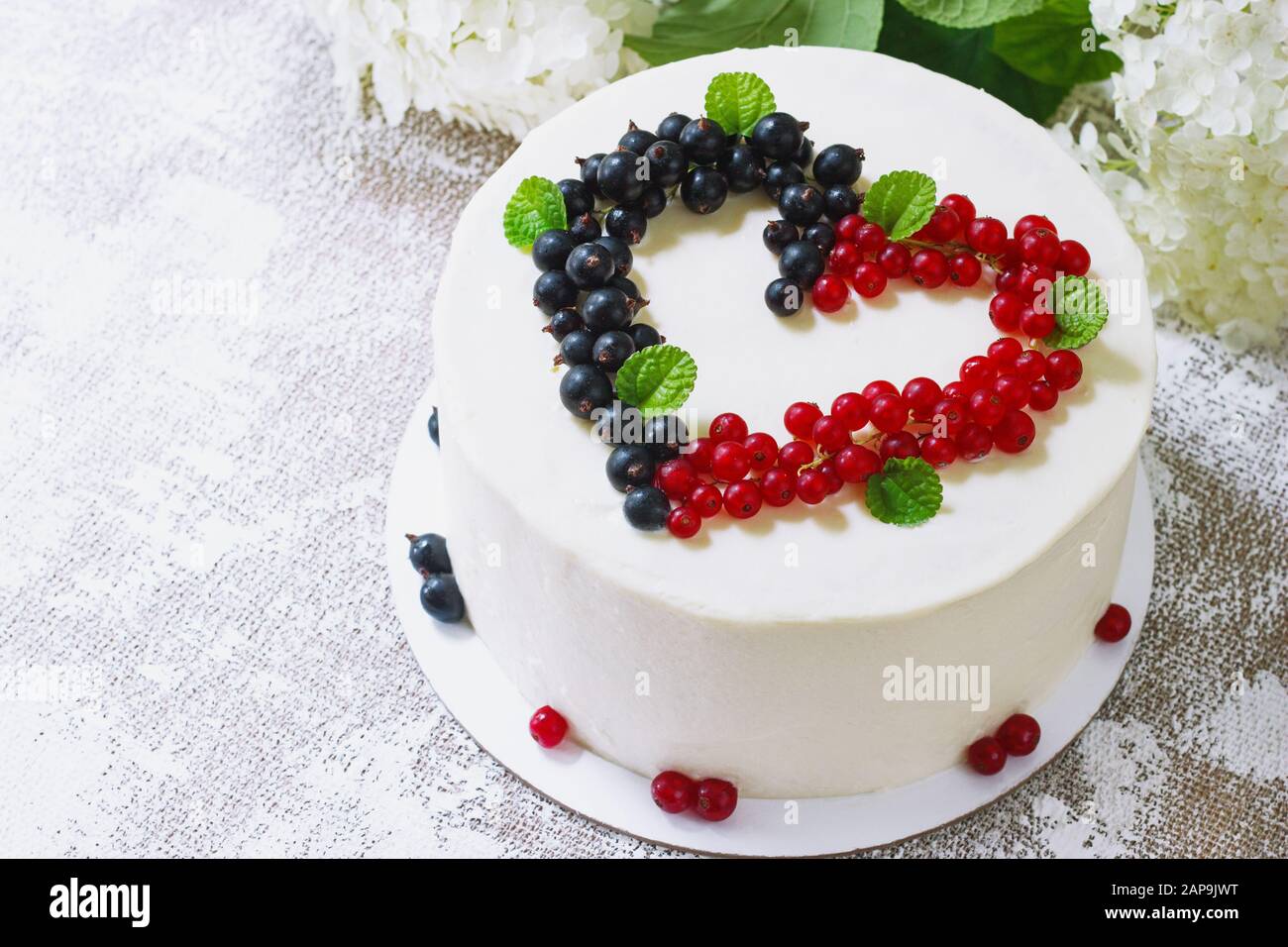 Round white cake with berries in the form of hearts, Valentine's Day ...
