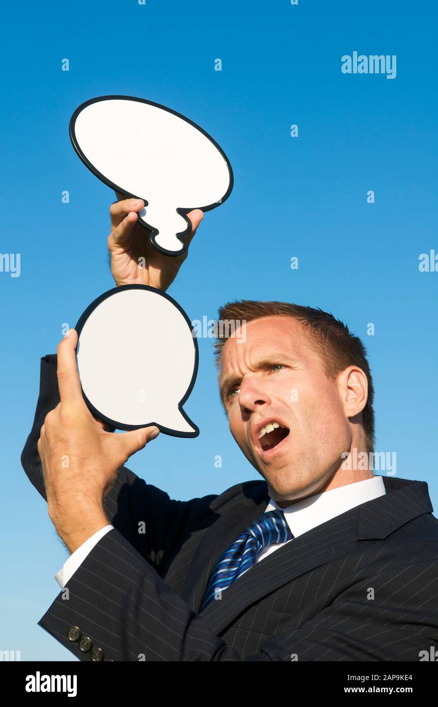 Confused businessman giving out mixed messages holding blank speech and ...