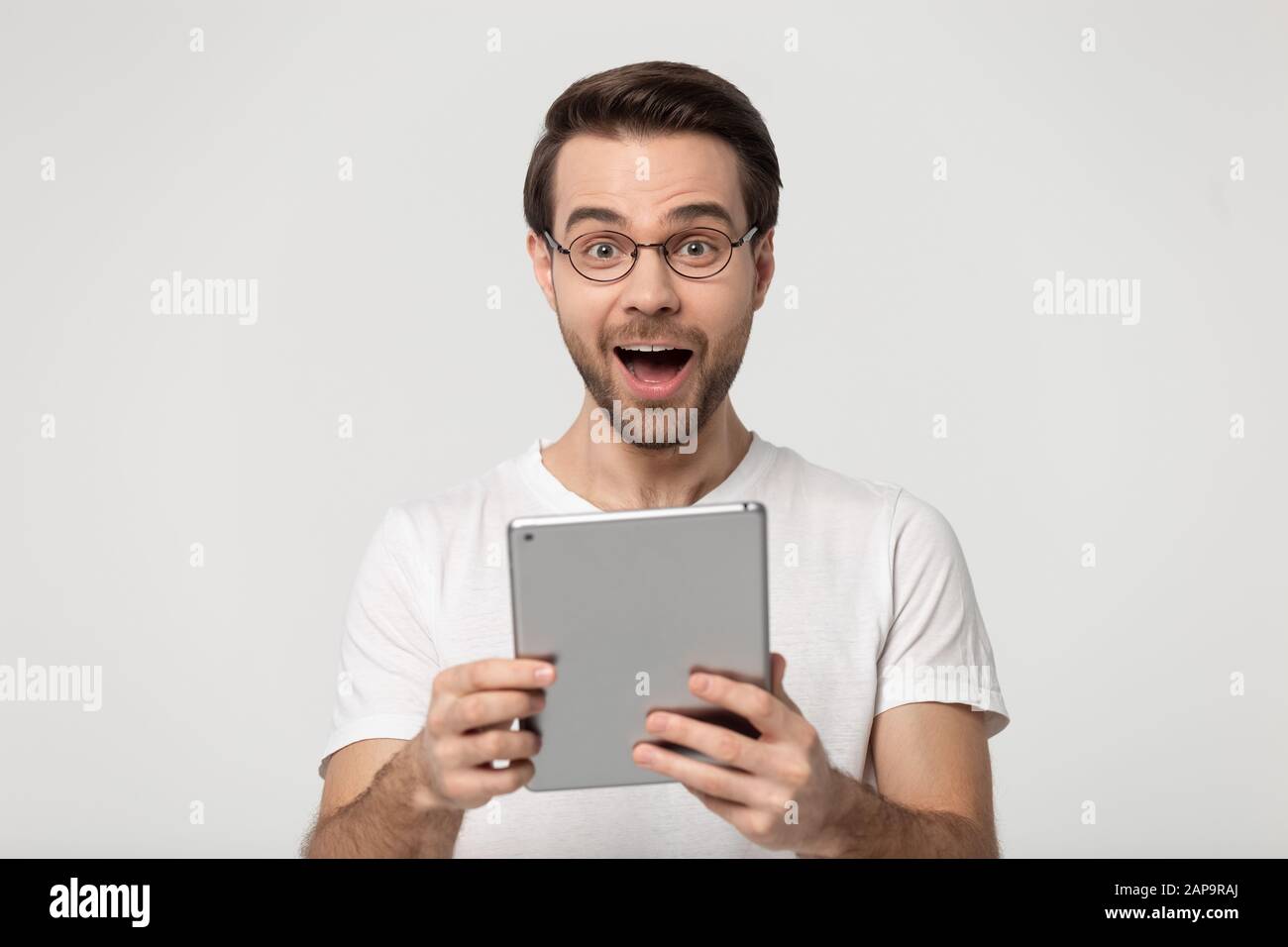 Excited young man holding digital gadget portrait Stock Photo - Alamy Excited young man holding digital gadget portrait Stock Photo - Alamy