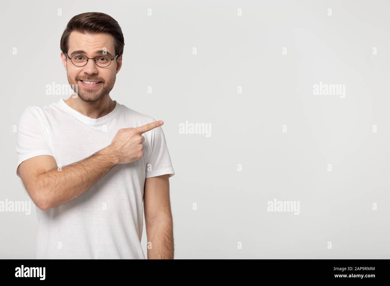 Happy smiling young guy standing aside pointing on empty space Stock ...
