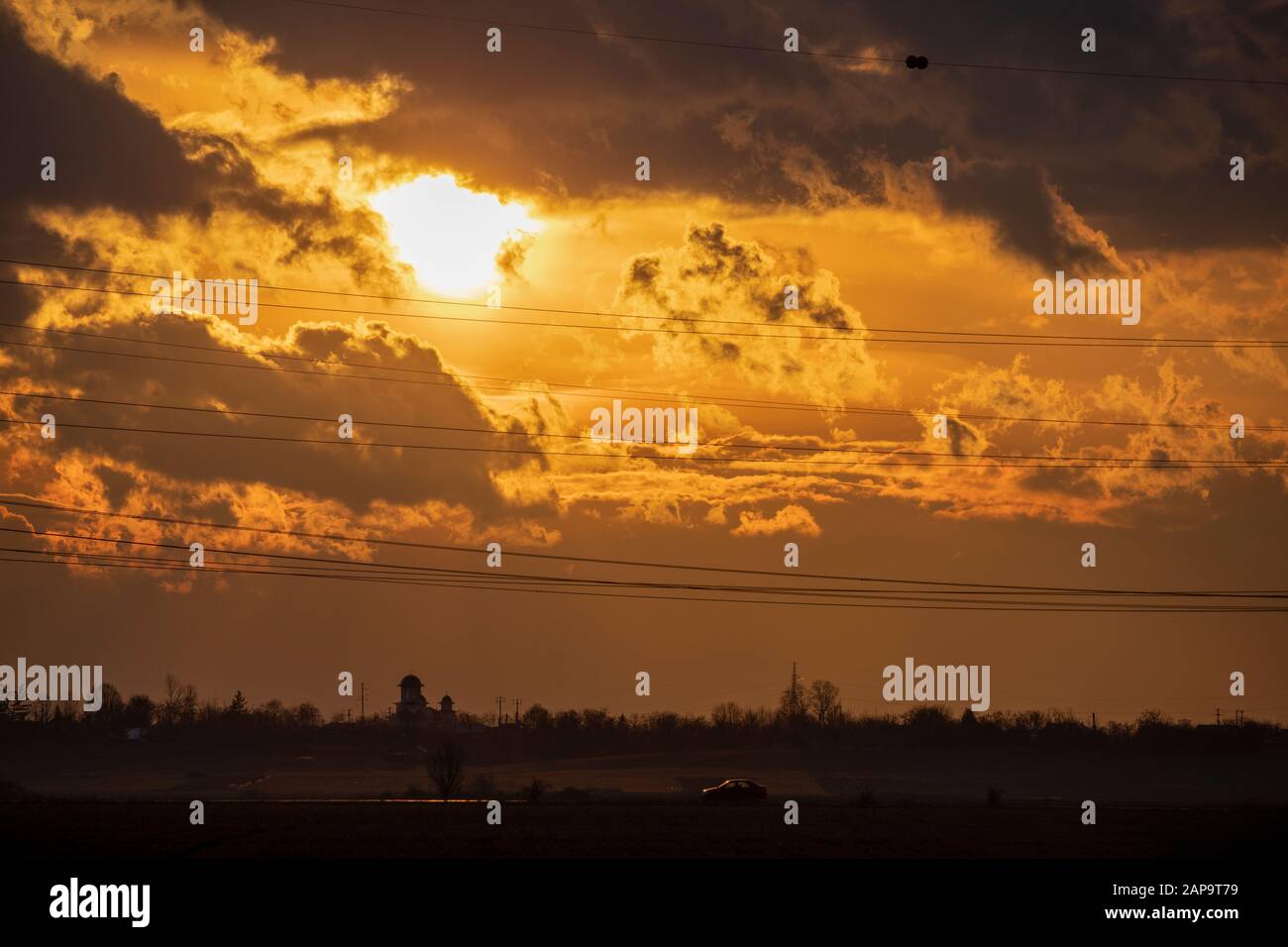 Sky at sunset with dark clouds and sun behind Stock Photo - Alamy