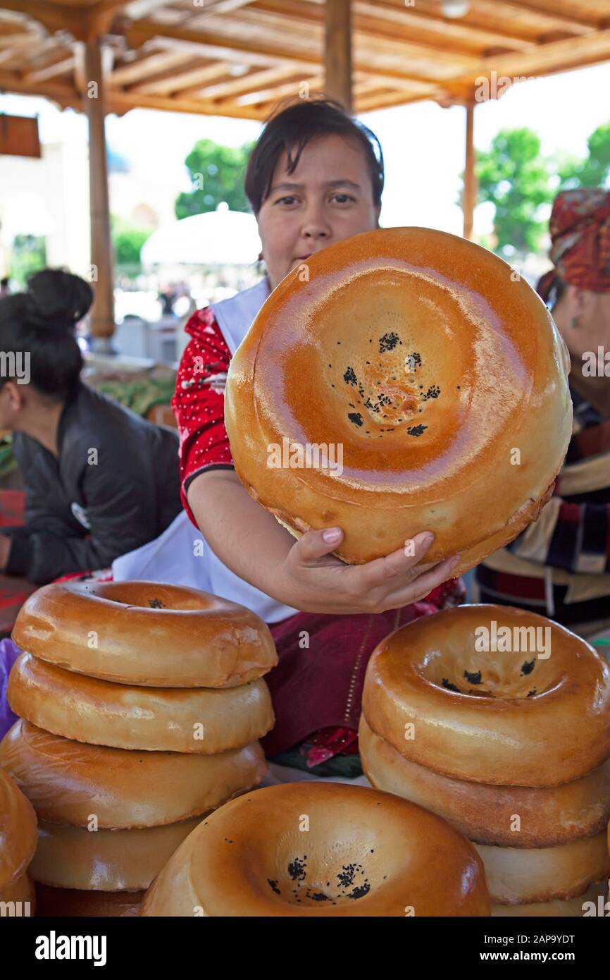 Woman shows a traditional Samarkand bread, Siyob bazaar Samarkand ...