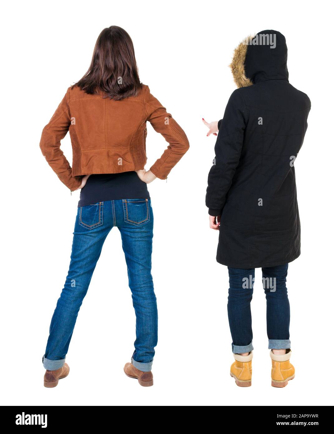 Back view of two pointing young girl in winter jacket. Rear view people ...