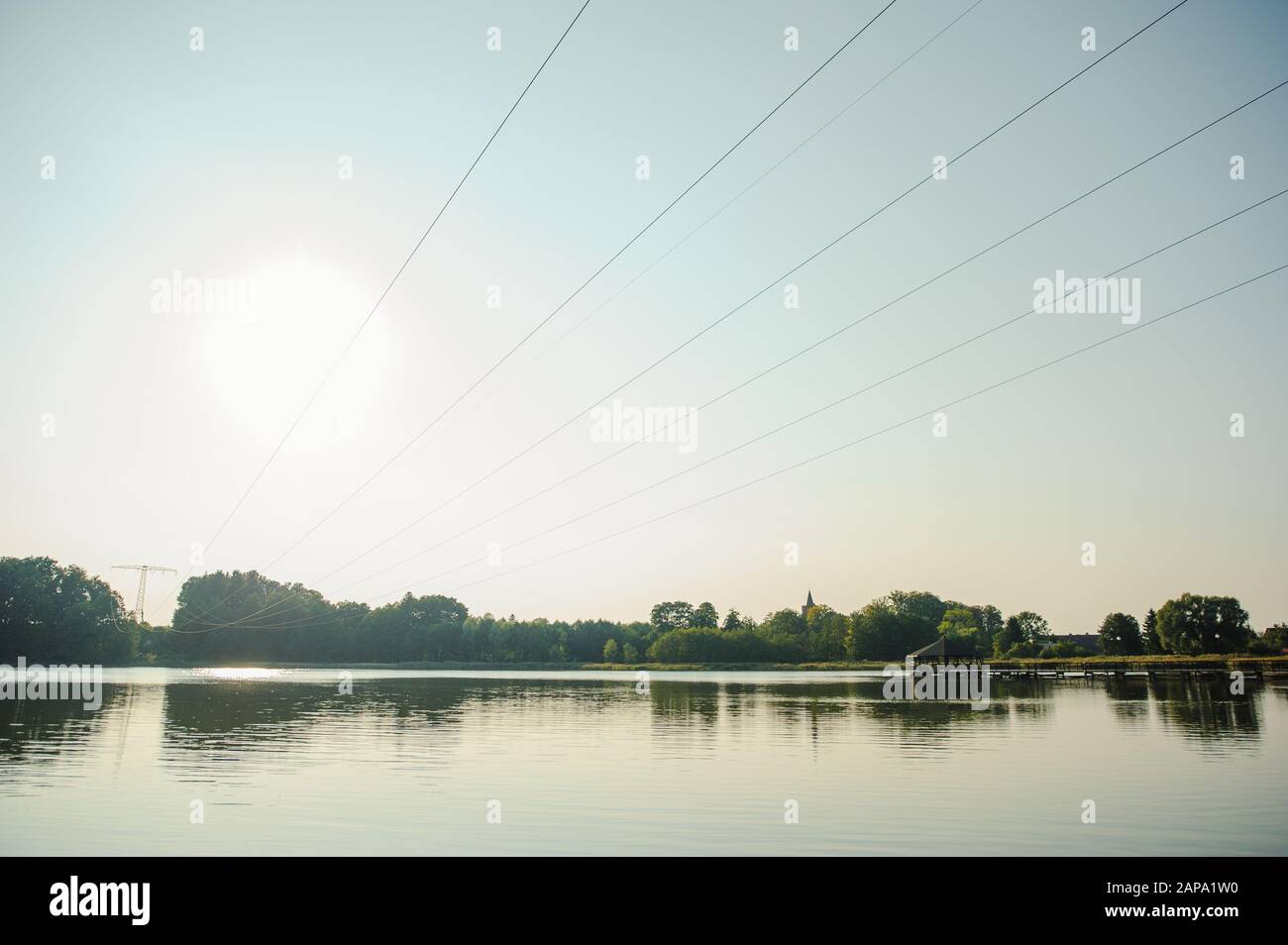 Sunset on the lake and transmission power line Stock Photo - Alamy